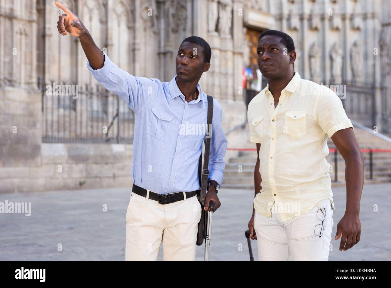 Two people talking and pointing finger at the street Stock Photo - Alamy