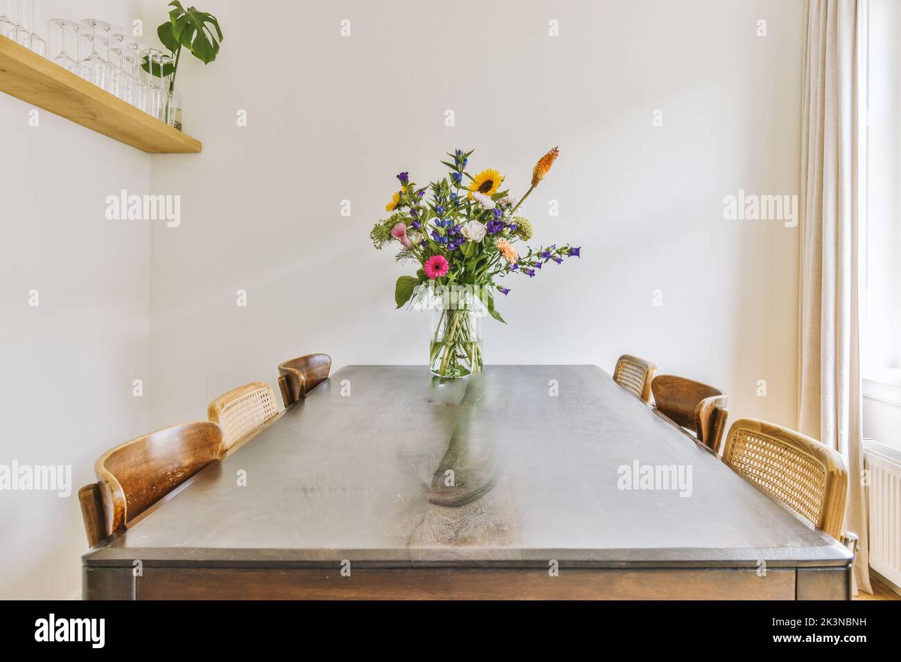 Shabby wooden table with chairs and vase located near comfortable couch ...