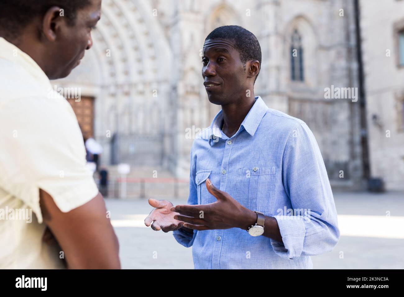 Positive African American talking with friend outdoors Stock Photo - Alamy