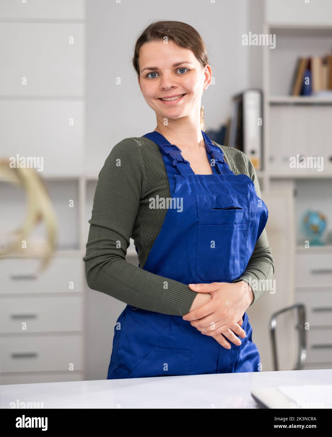 Female cleaning service worker standing in office Stock Photo - Alamy