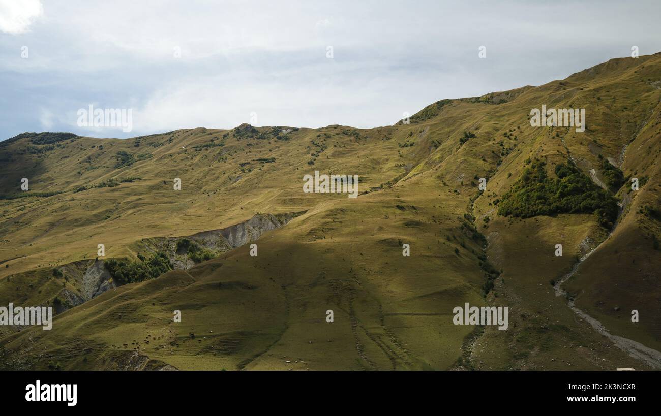 A beautiful view of a green mountain's peak against the cloudy sky ...