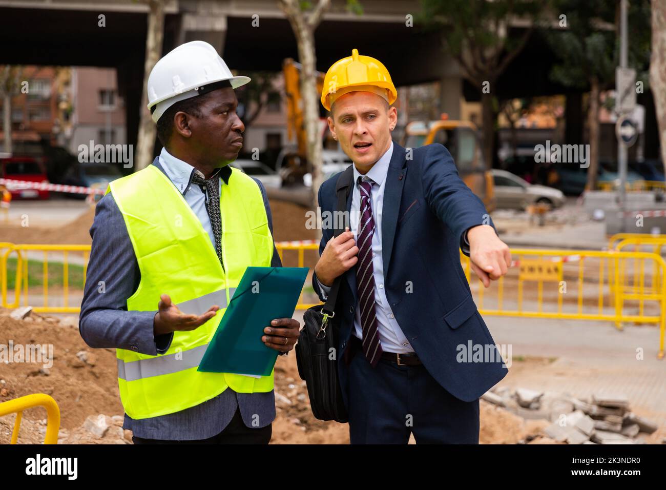 Architect tells engineer where to dig a trench to lay pipe Stock Photo ...
