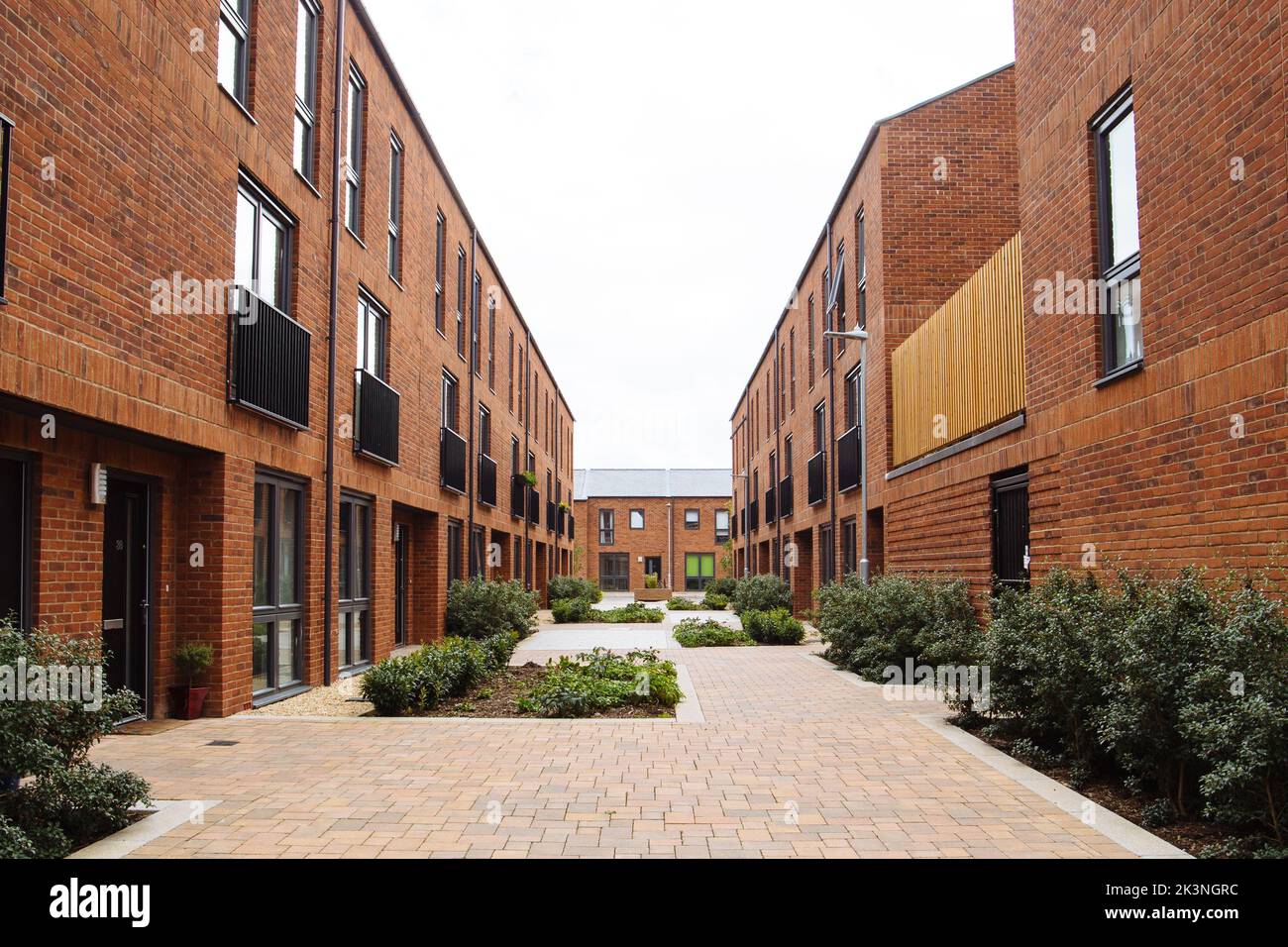 Red brick buildings with a walkway and planters Stock Photo - Alamy