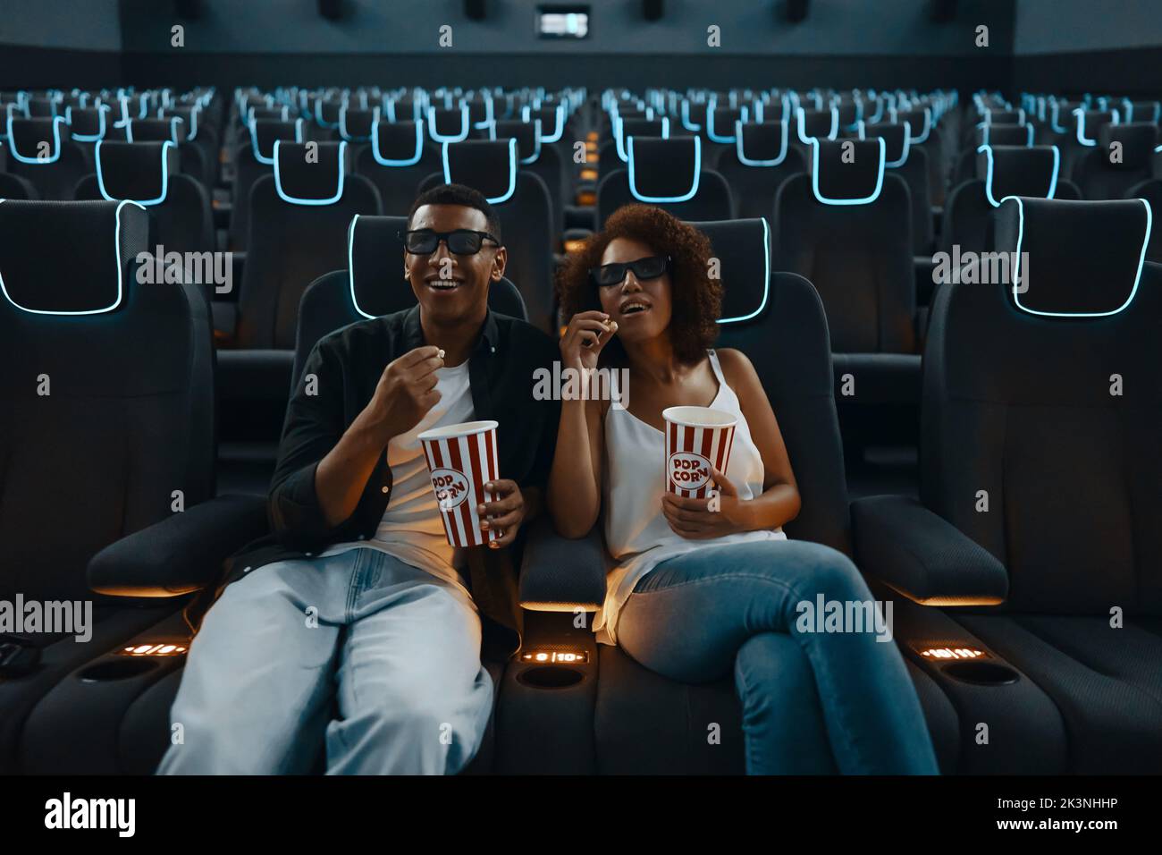 A couple with popcorn in an empty cinema watching a movie Stock Photo ...