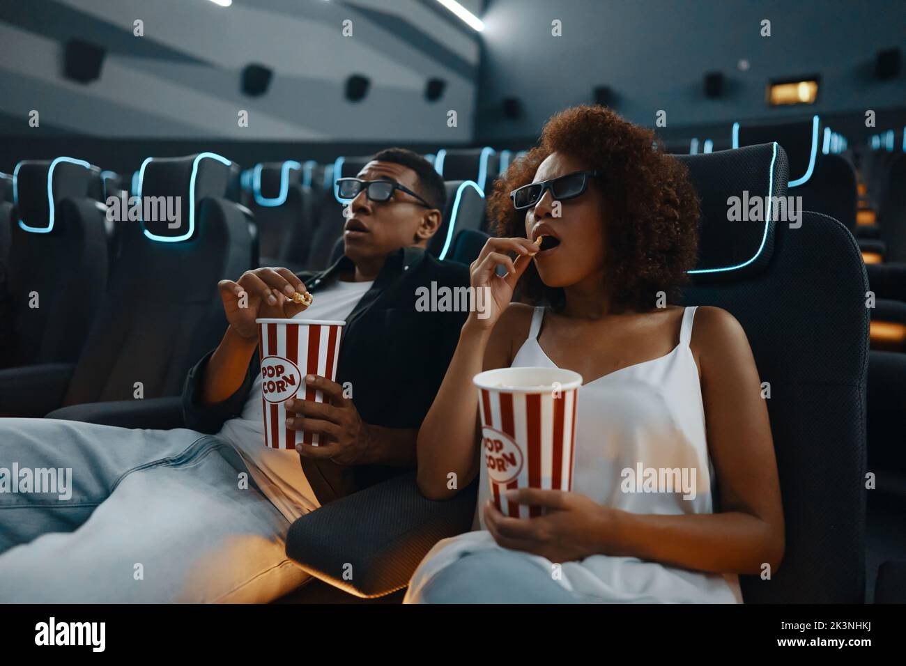 A couple with popcorn in an empty cinema watching a movie Stock Photo ...