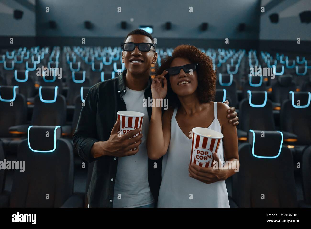 A couple with popcorn in an empty cinema watching a movie Stock Photo ...