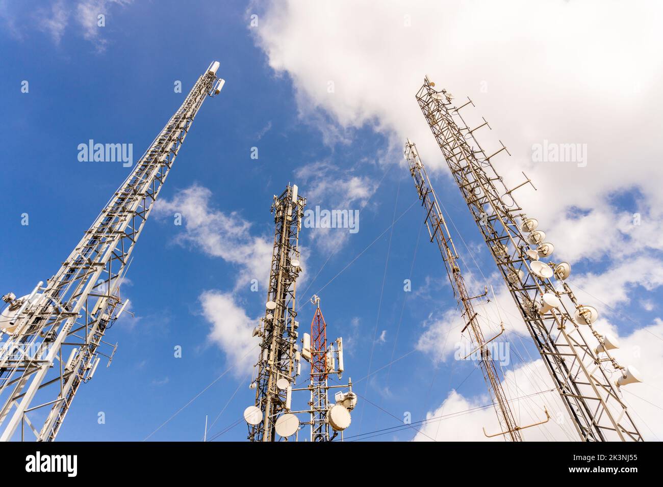 A low angle shot of tall cell towers against the sky Stock Photo - Alamy