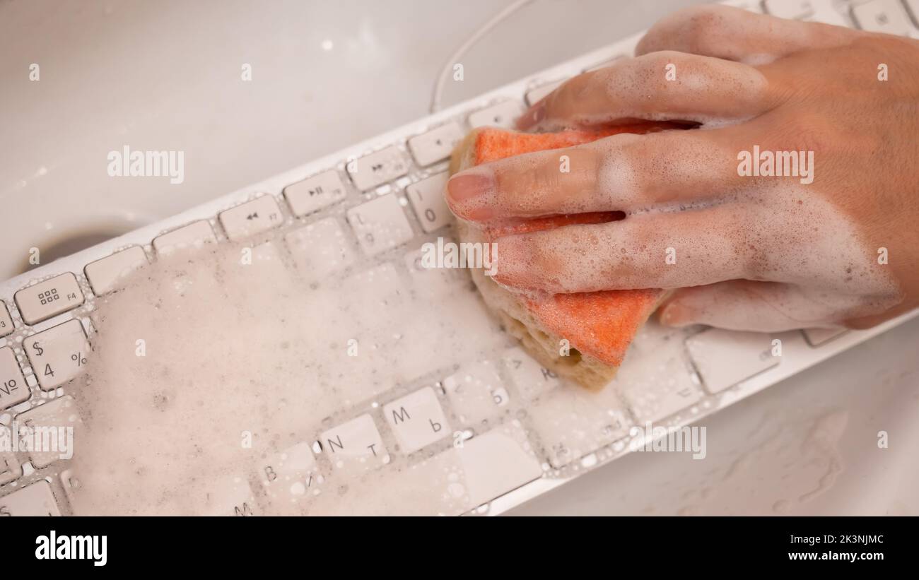 Woman washing white computer keyboard with a sponge with foam Stock ...