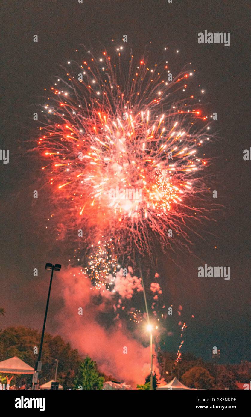 A vertical shot of a glowing firework in the sky at night Stock Photo ...