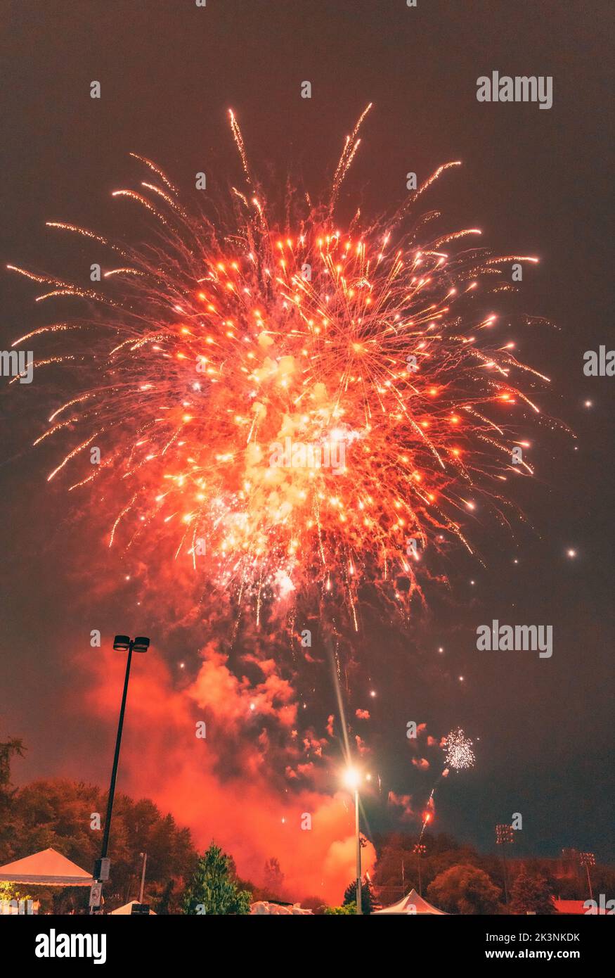 A vertical shot of a glowing firework in the sky at night Stock Photo ...