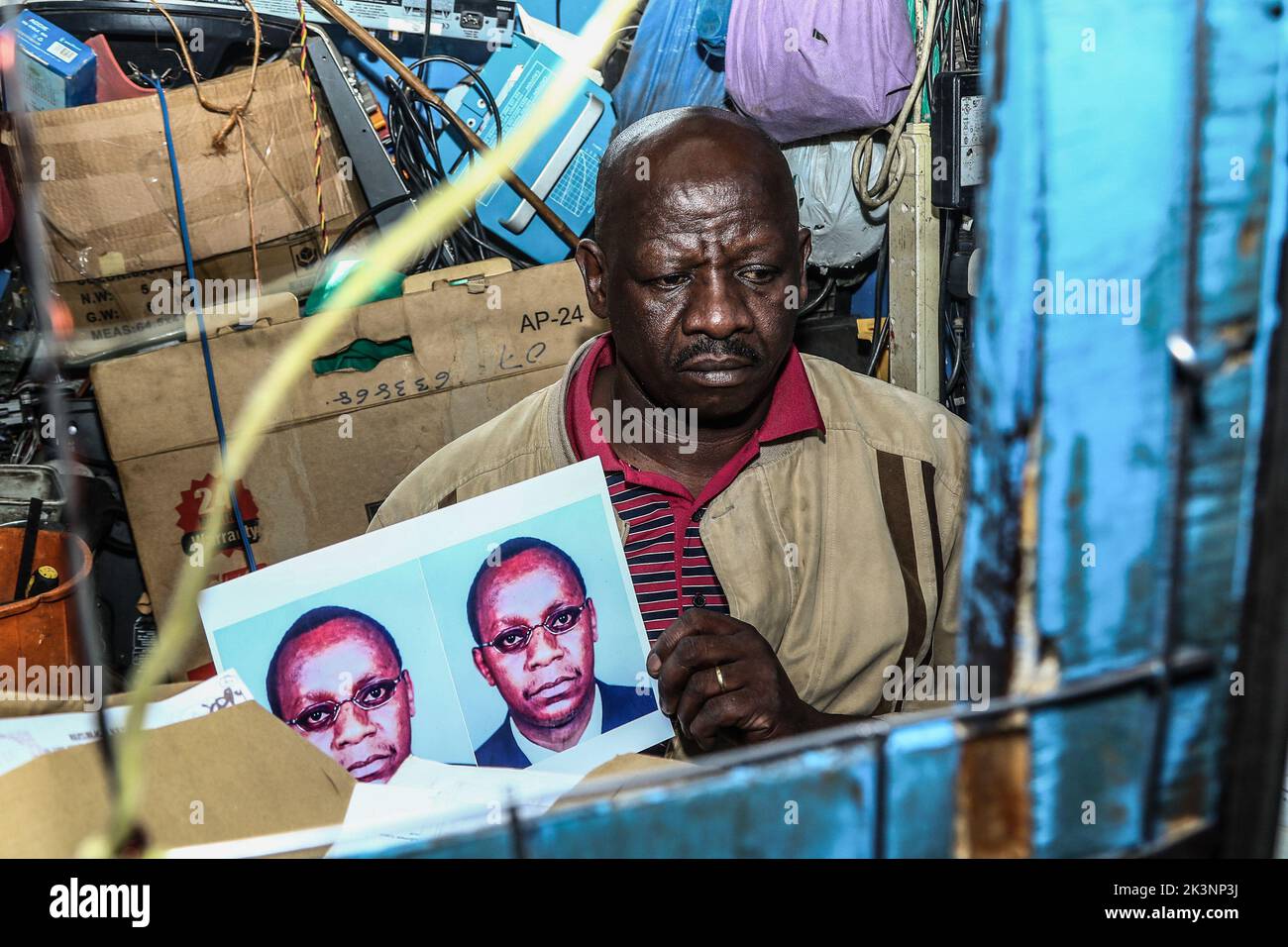Josephat Mureithi, holds portraits of his slain brother, William Munuhe ...