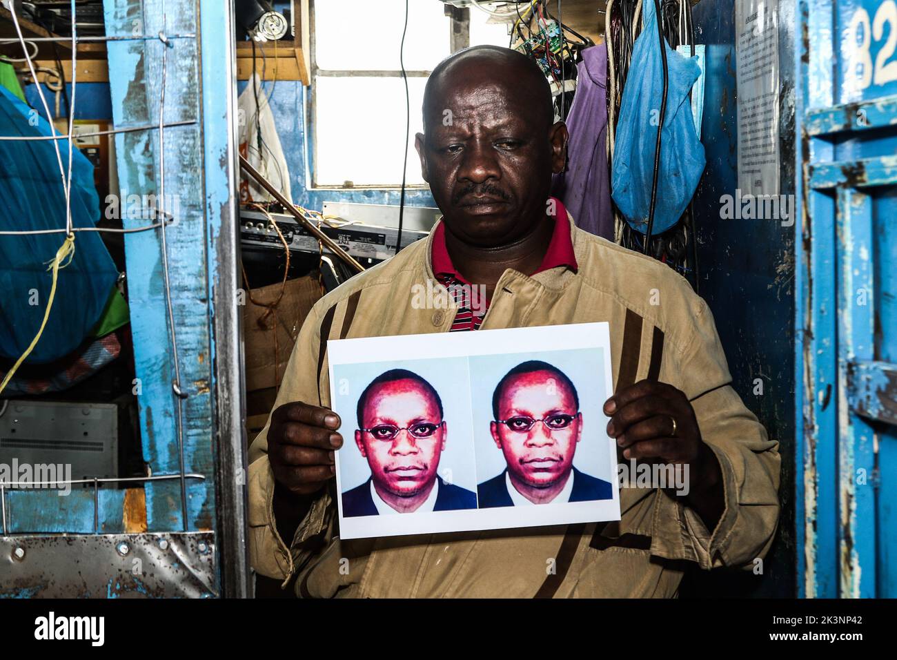 Josephat Mureithi, holds portraits of his slain brother, William Munuhe ...