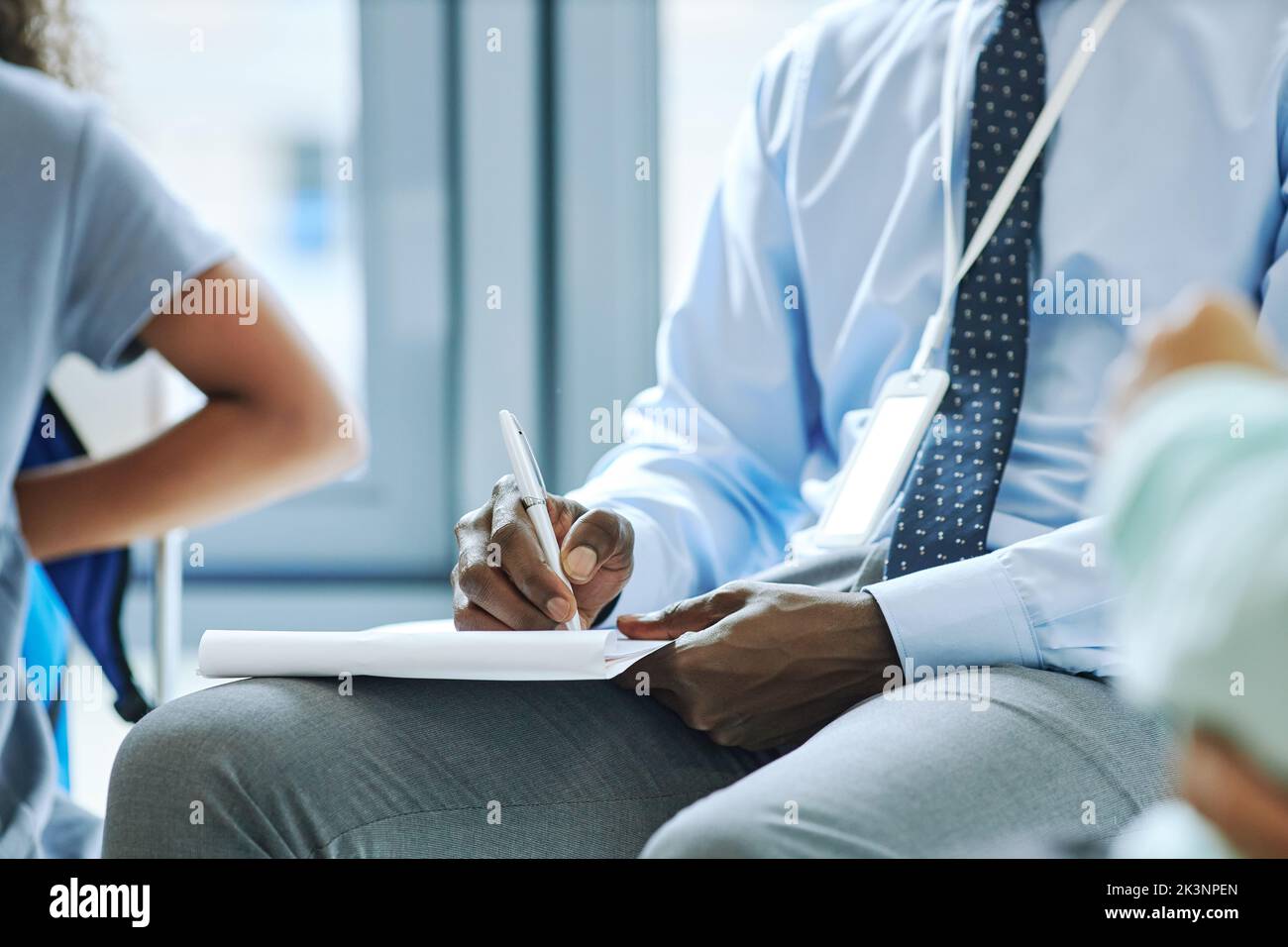 Close up of unrecognizable male therapist taking notes during session ...