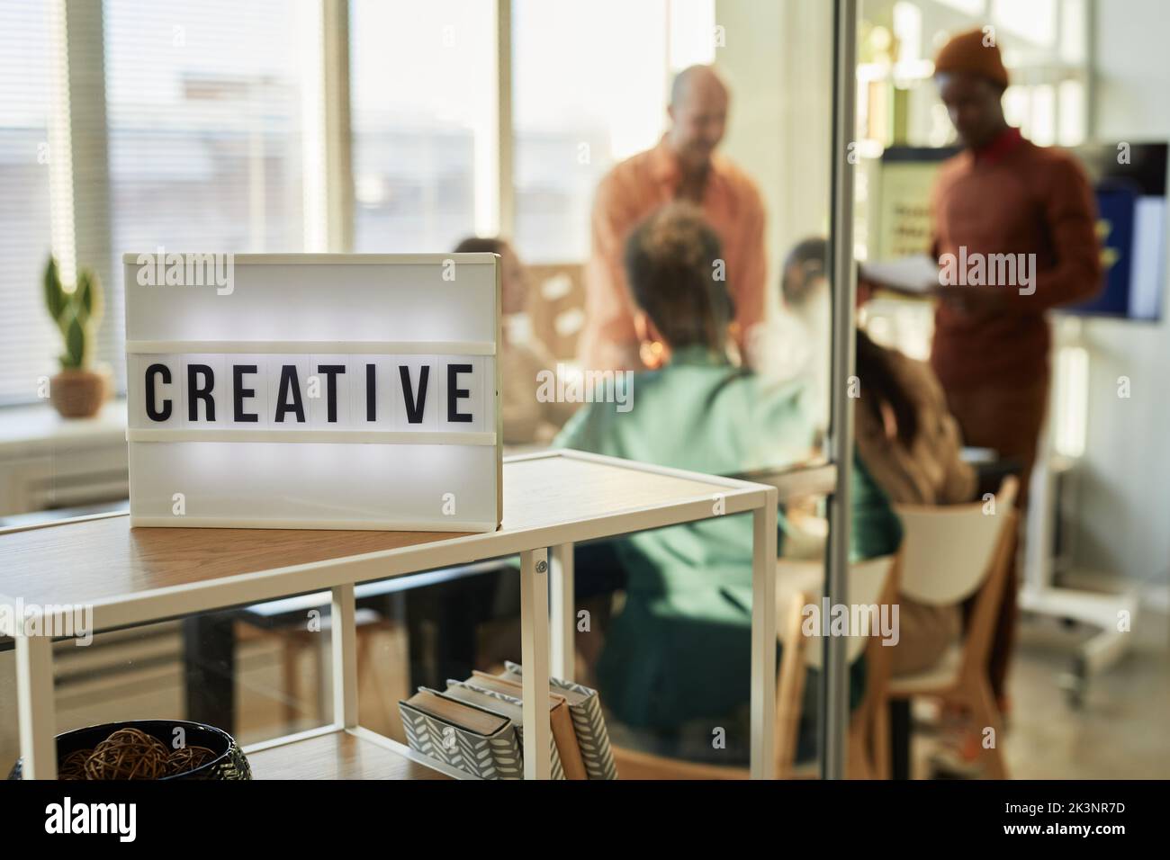 Background image of CREATIVE light up sign in office with people ...