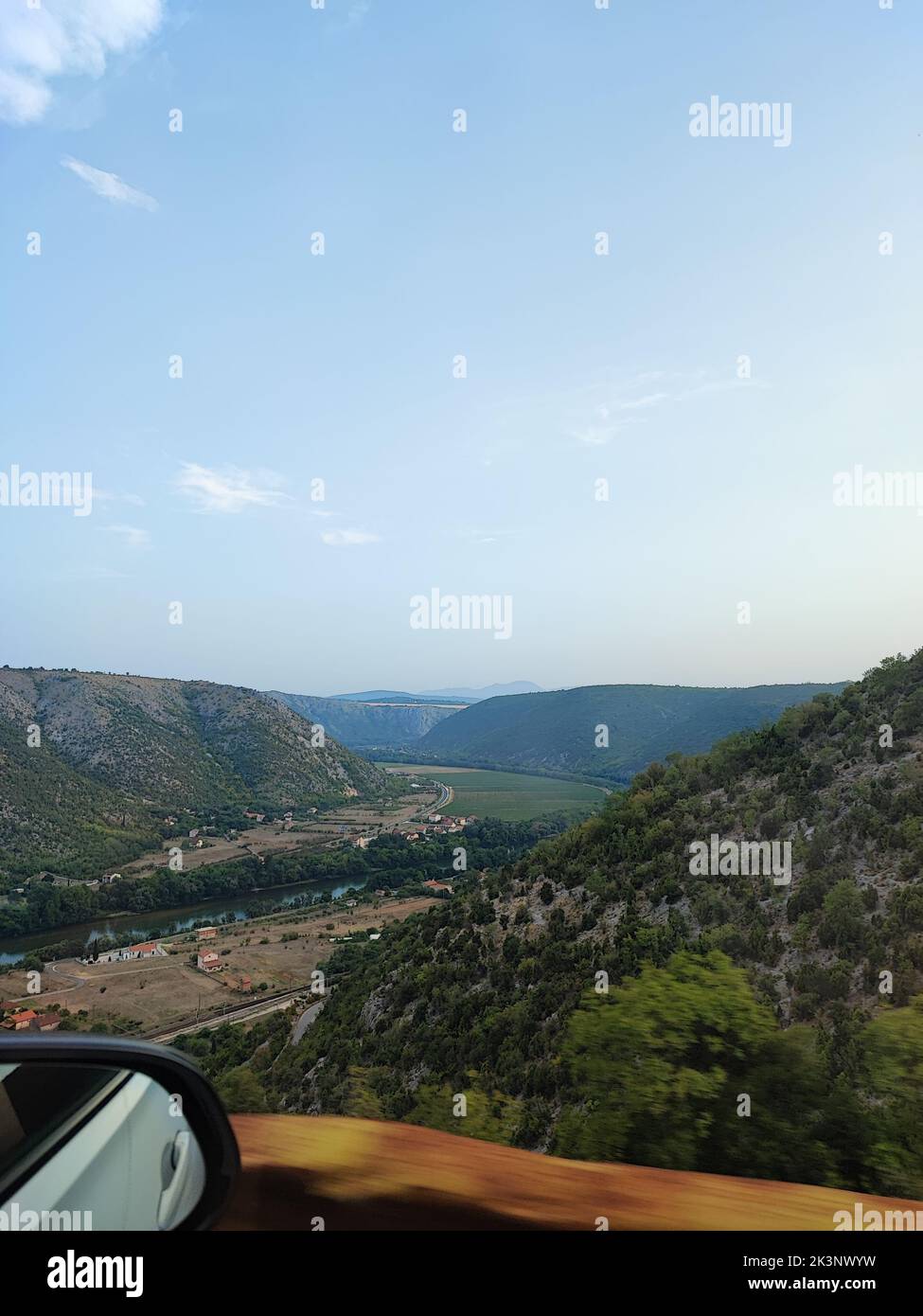 A vertical shot of forested mountains captured from a car in Mostar ...