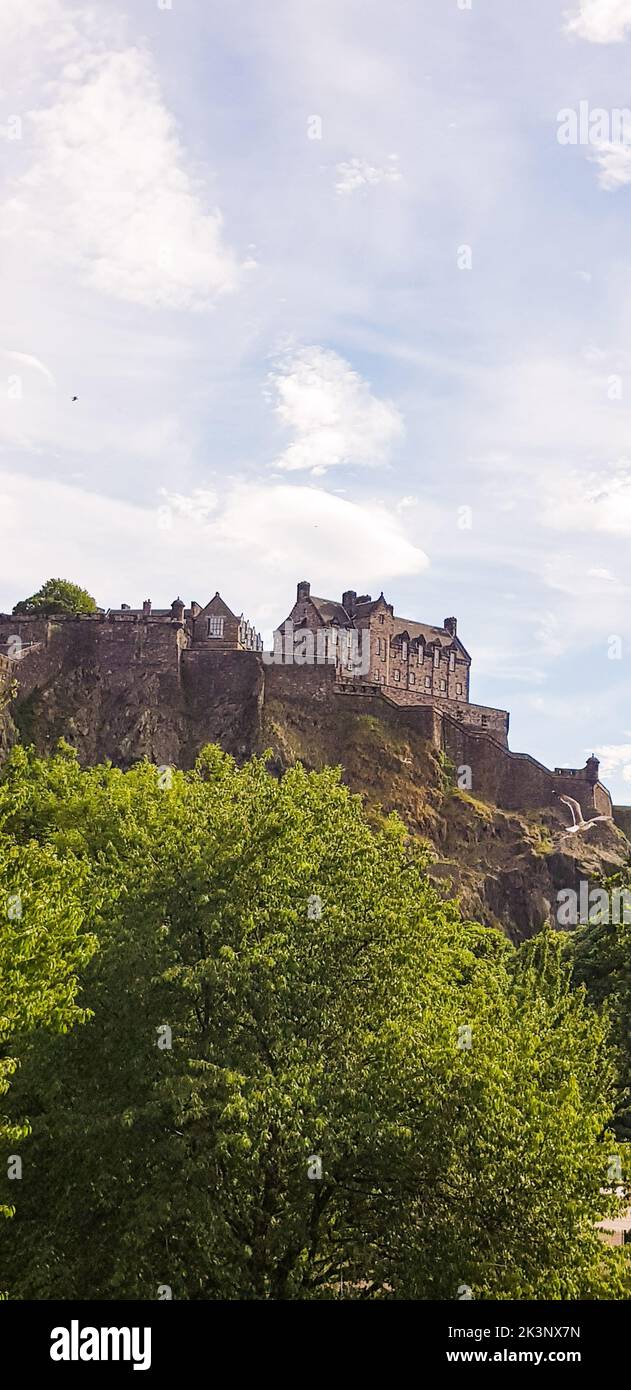A scenic view of the historic Edinburgh castle surrounded by greenery ...