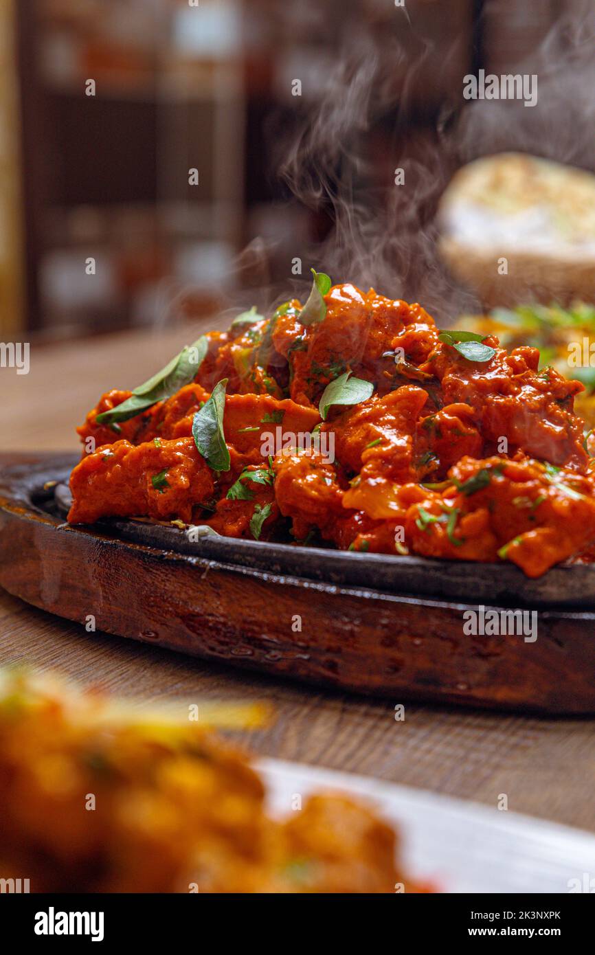A hot steam coming from delicious Indian chicken dish served during a ...