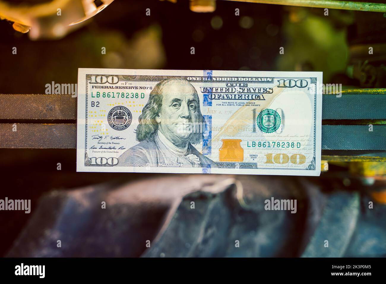 Hundred dollar bill close-up on an industrial background. Money on belt ...