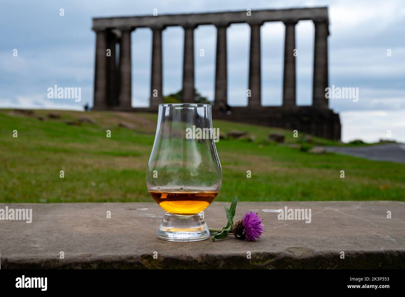 Dram glass of single malt scotch whisky and view from Calton hill to ...