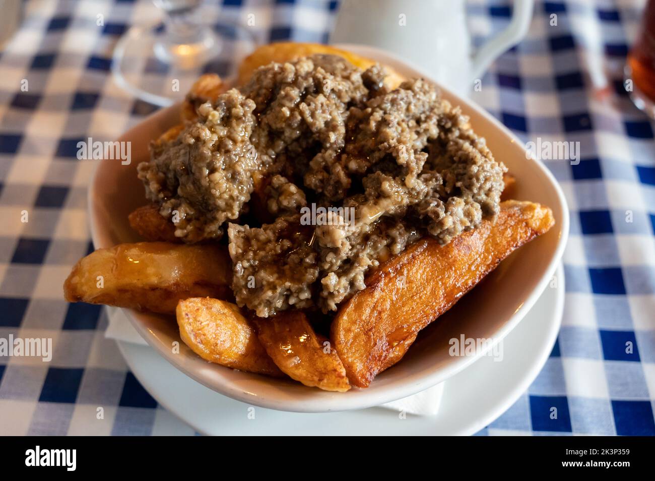 Scottish traditional snack food, hand cut potato chips topped with ...