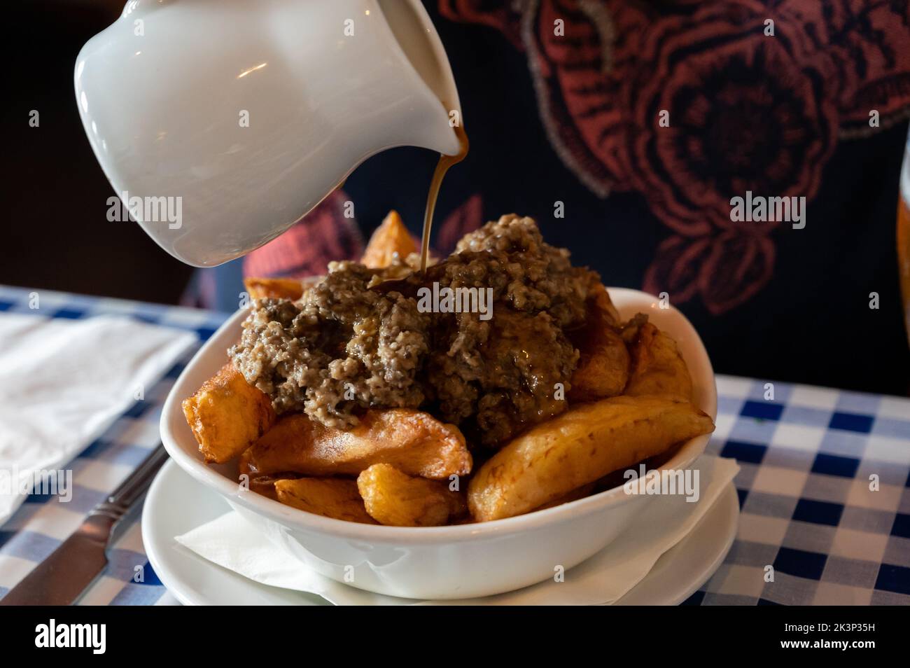 Scottish traditional snack food, hand cut potato chips topped with ...