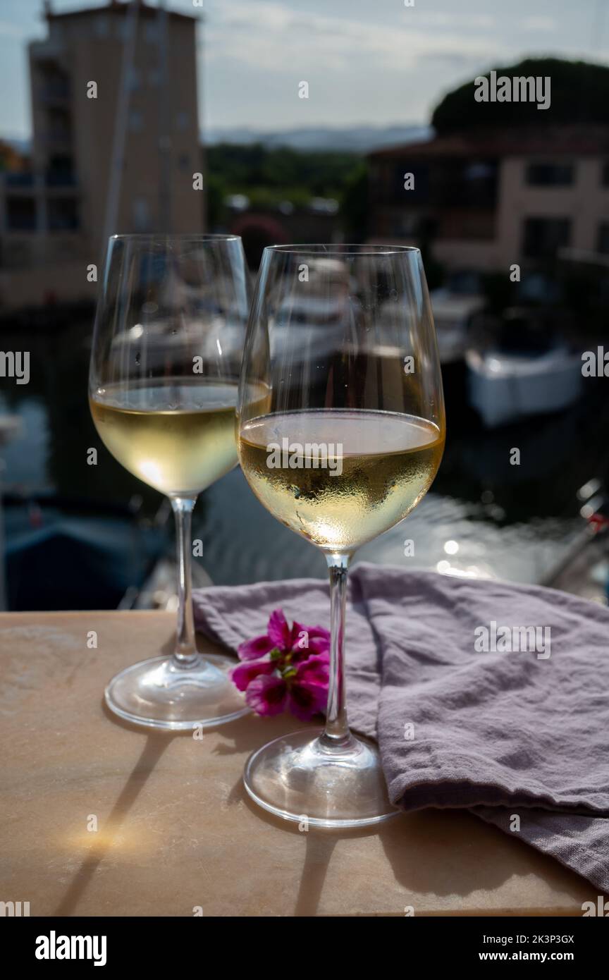 Drinking of cold white wine with view on yacht harbour of Port Grimaud ...