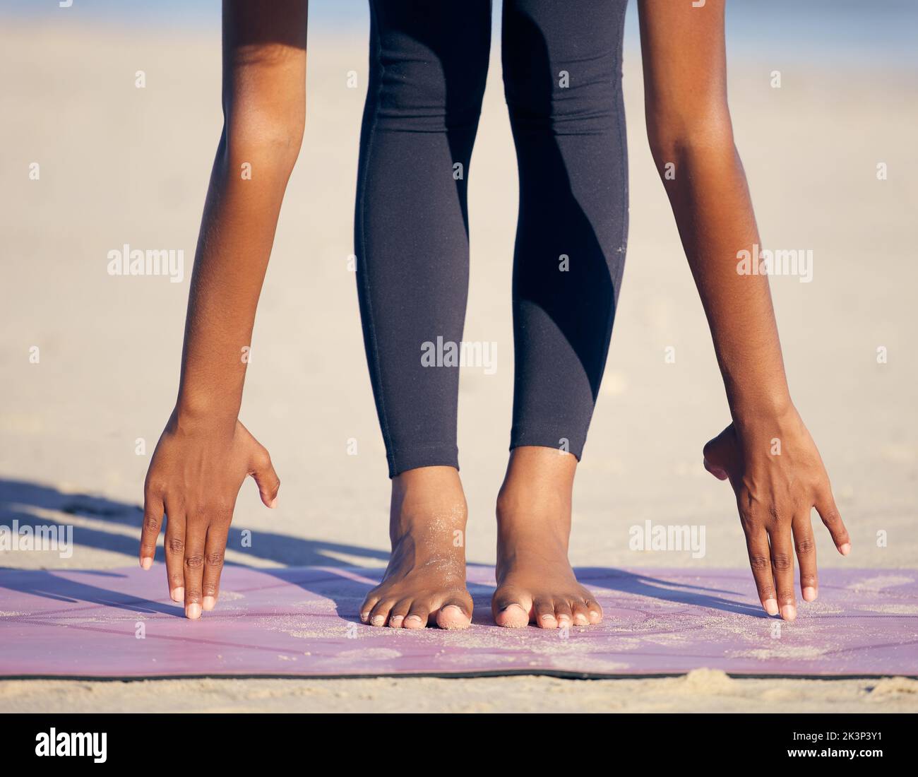 Stretch it out. an unrecognizable woman practicing yoga on the beach ...