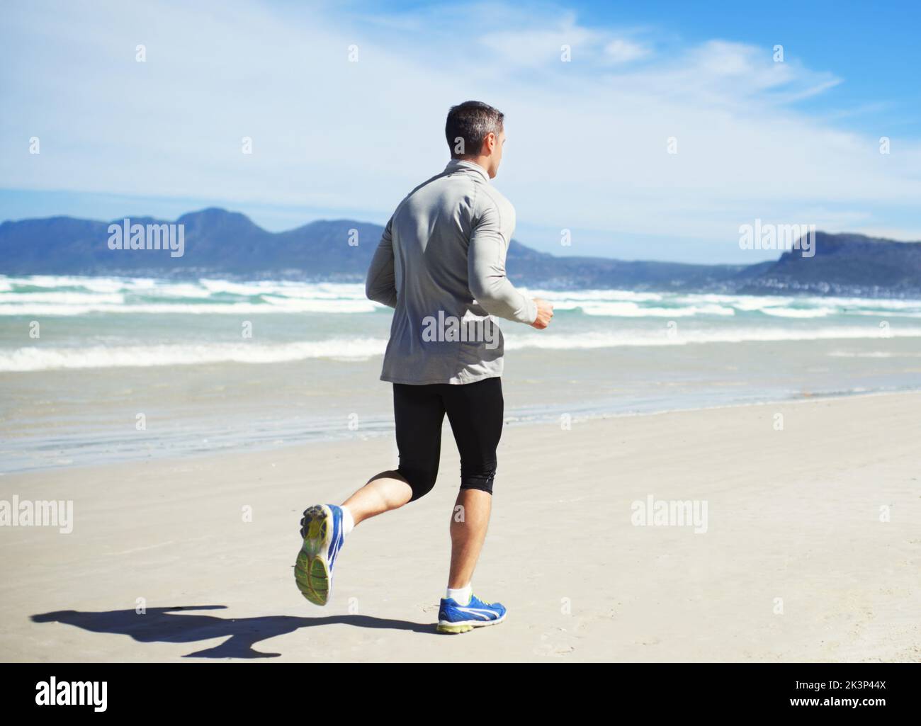 Man running along the beach hi-res stock photography and images - Alamy