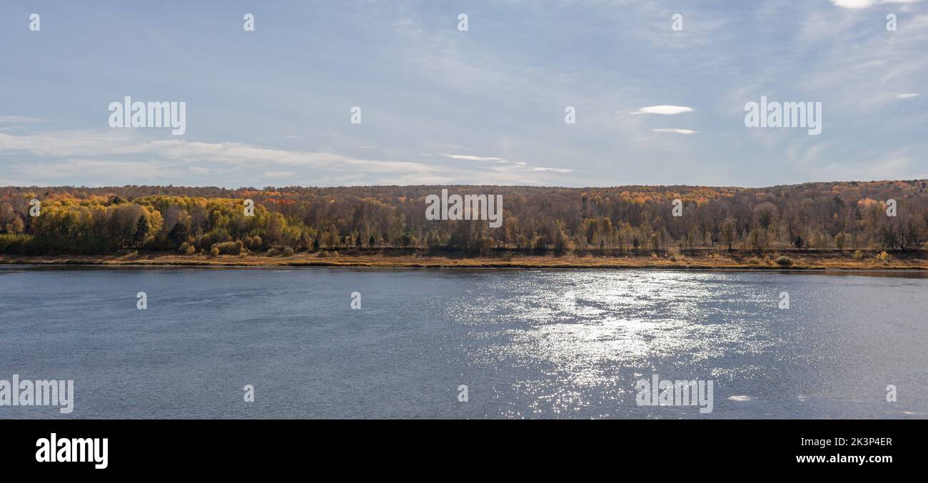 Beautiful, wide autumn river among forests and rocky shore. A calm and ...
