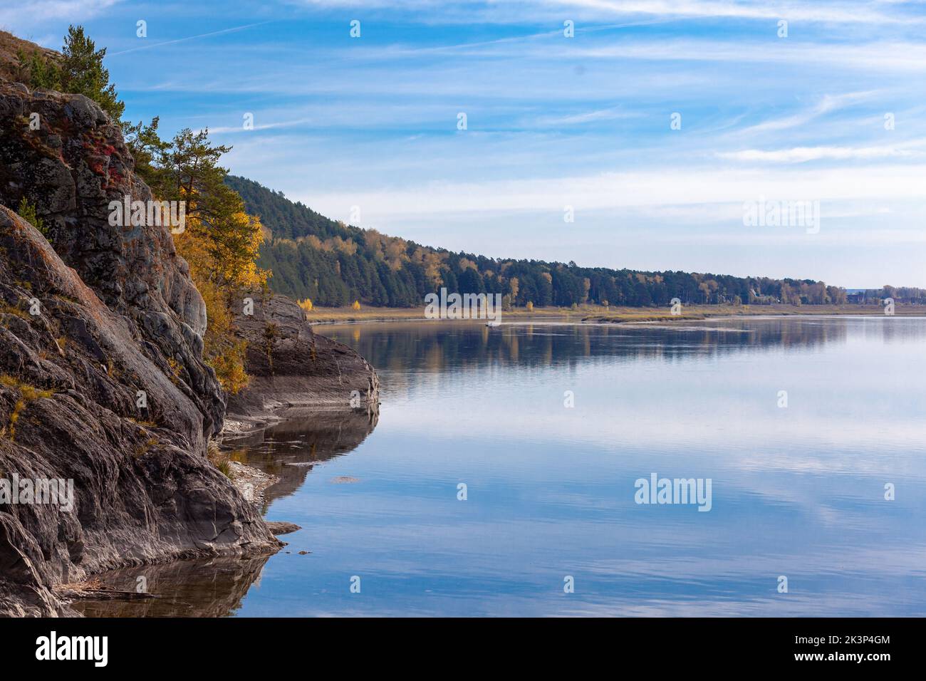 Beautiful, wide autumn river among forests and rocky shore. A calm and ...