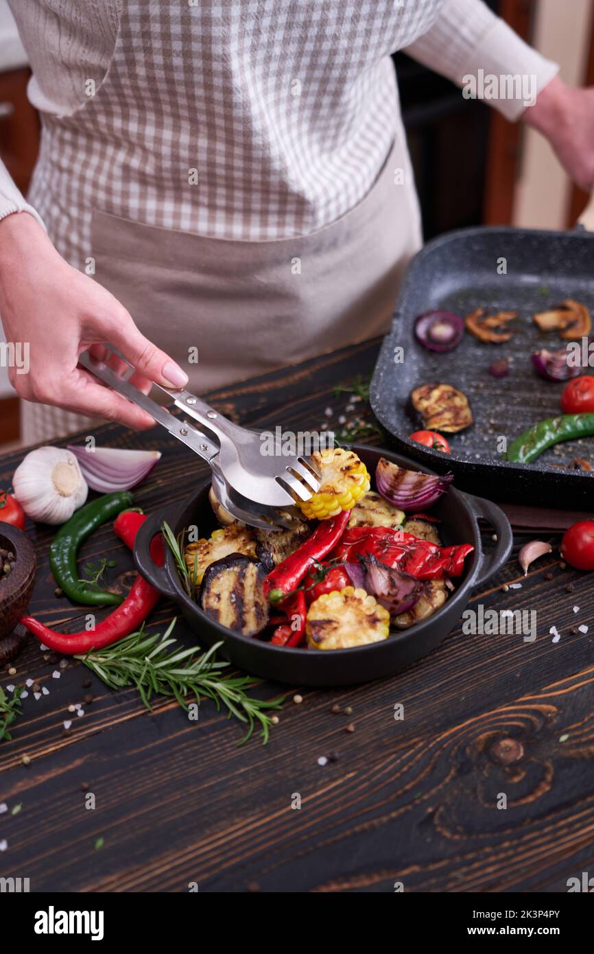 Grilled vegetables in black ceramic plate on table at domestic kitchen ...
