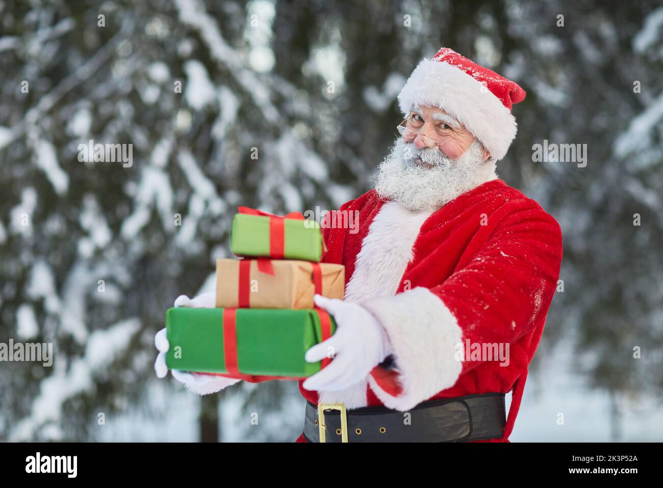 Waist up portrait of traditional Santa Claus holding stack of presents ...