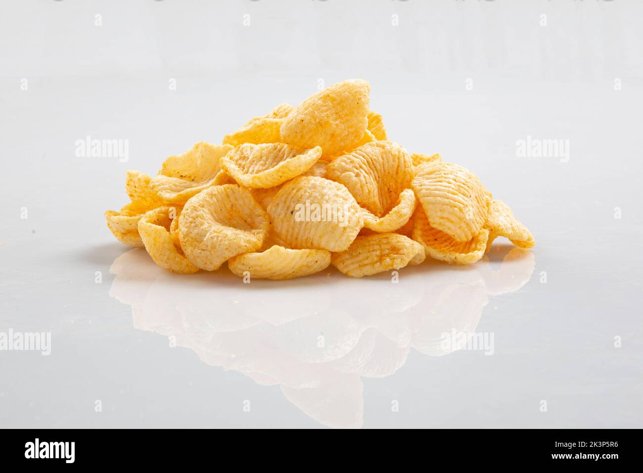 Potato chips falling into glass bowl isolated on white background with ...