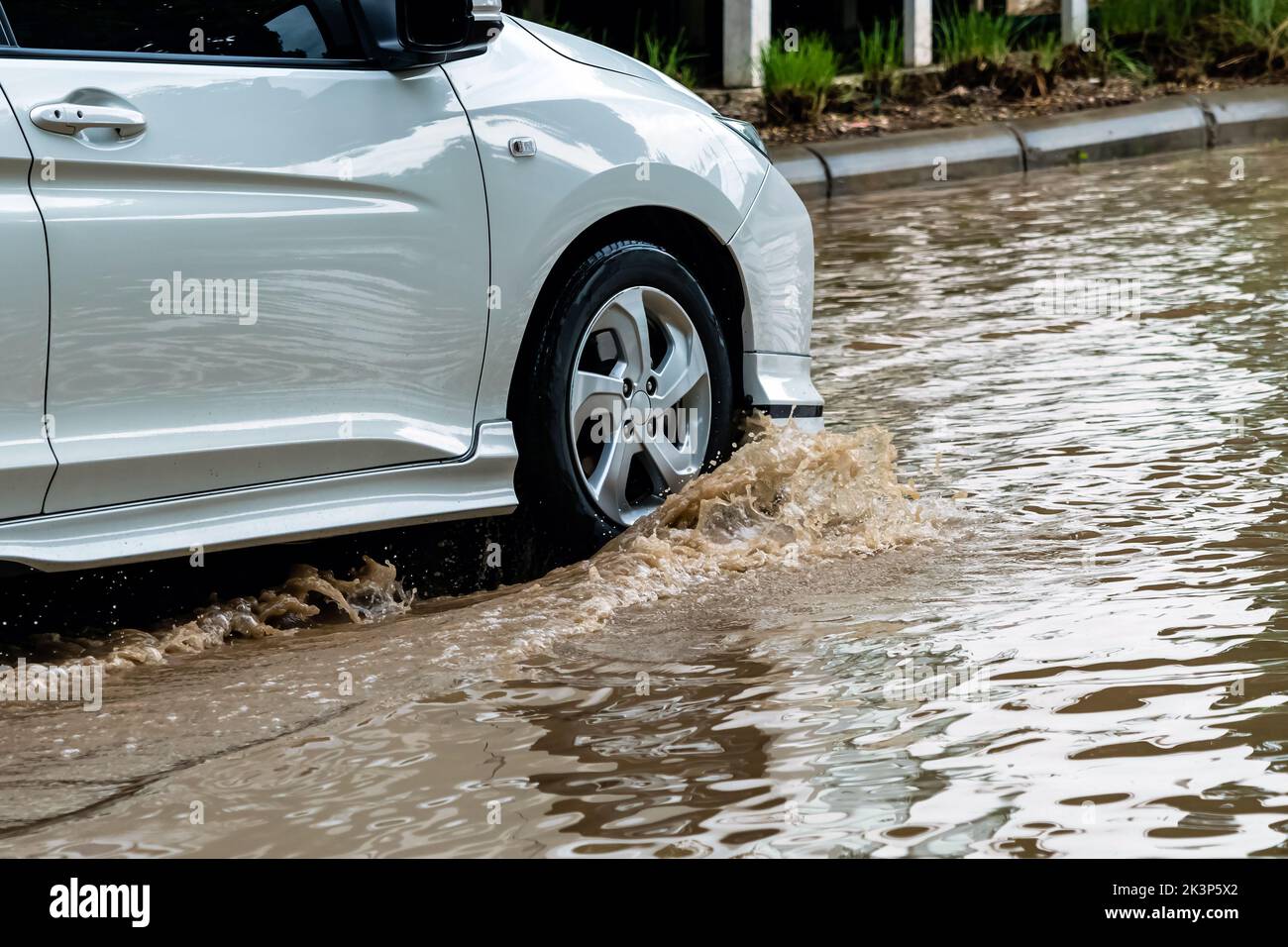 Car passing through a flooded road. Driving car on flooded road during ...
