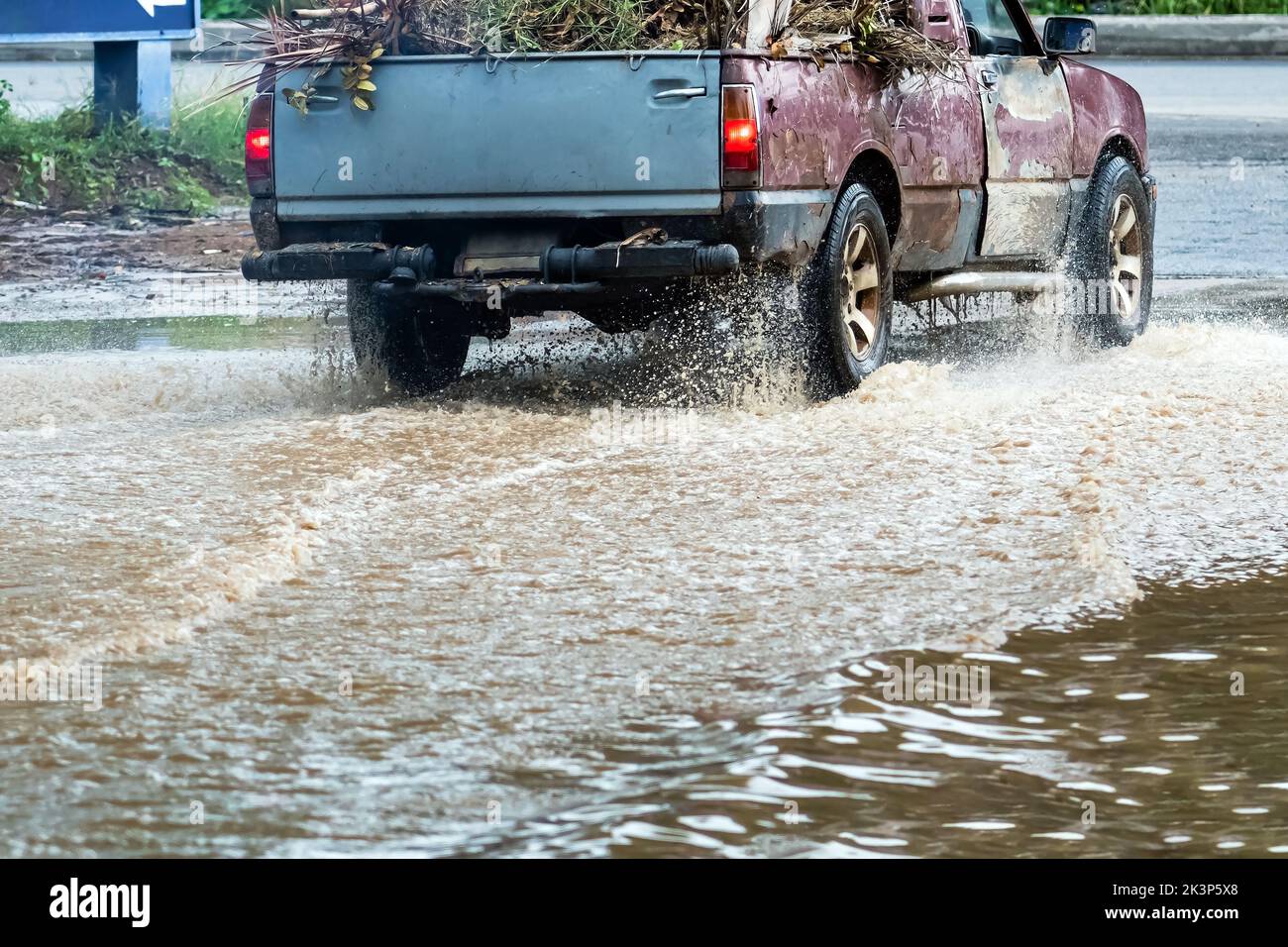 Pickup truck passing through flooded road. Driving car on flooded road ...