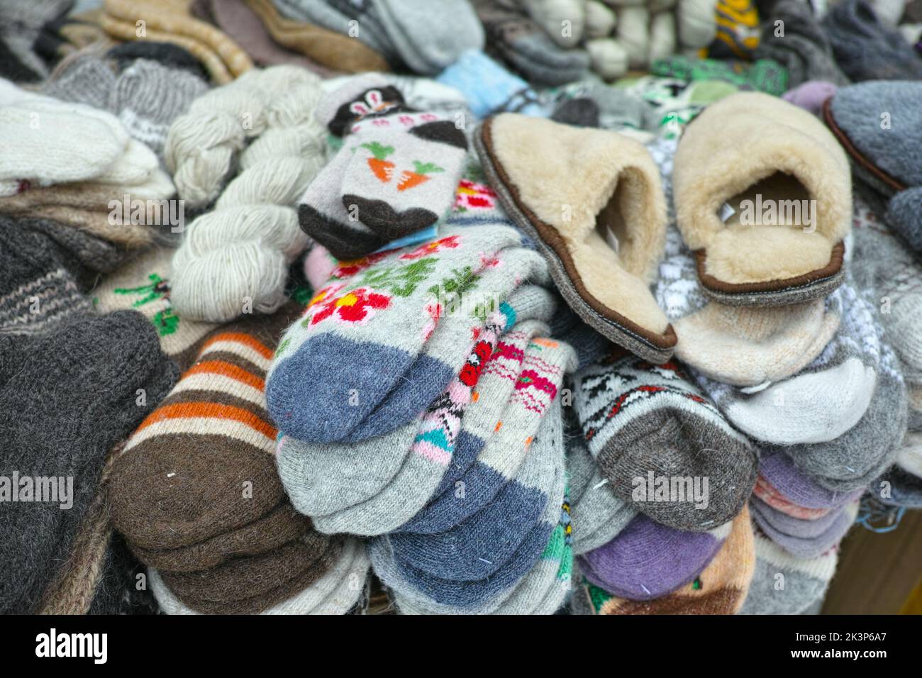 sale of handmade multi-color warm wool socks and slippers displayed ...