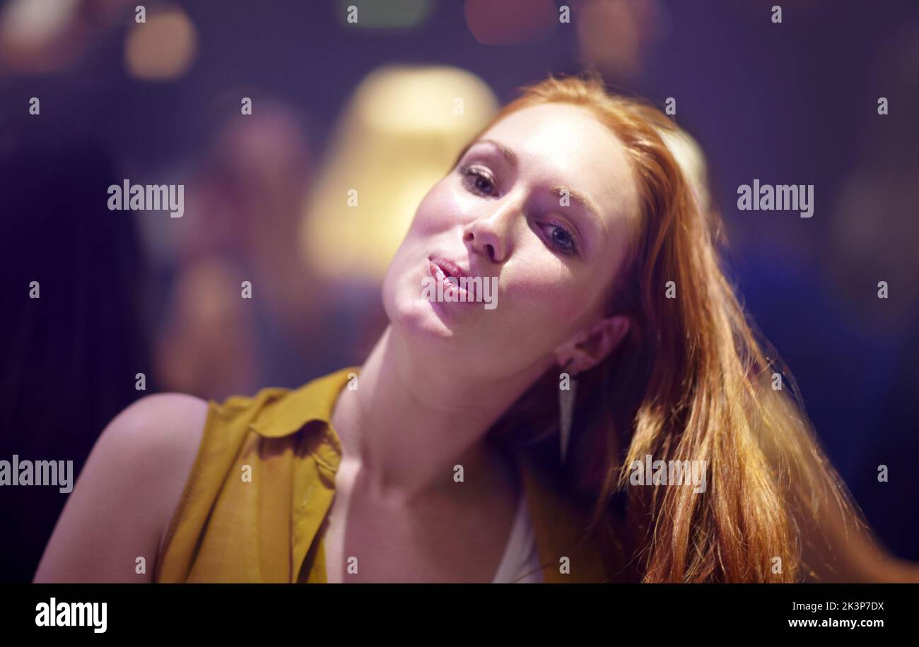 Letting loose at the club. A pretty young woman partying it up with ...