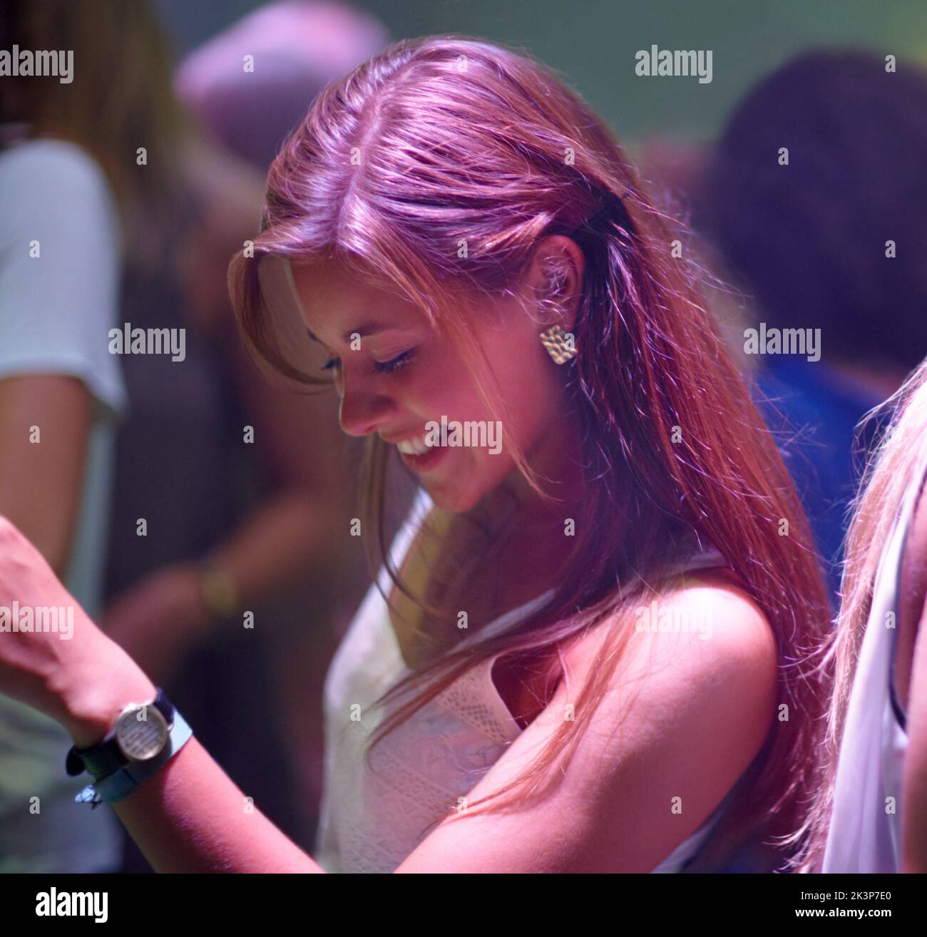 Letting loose at the club. A pretty young woman partying it up with ...