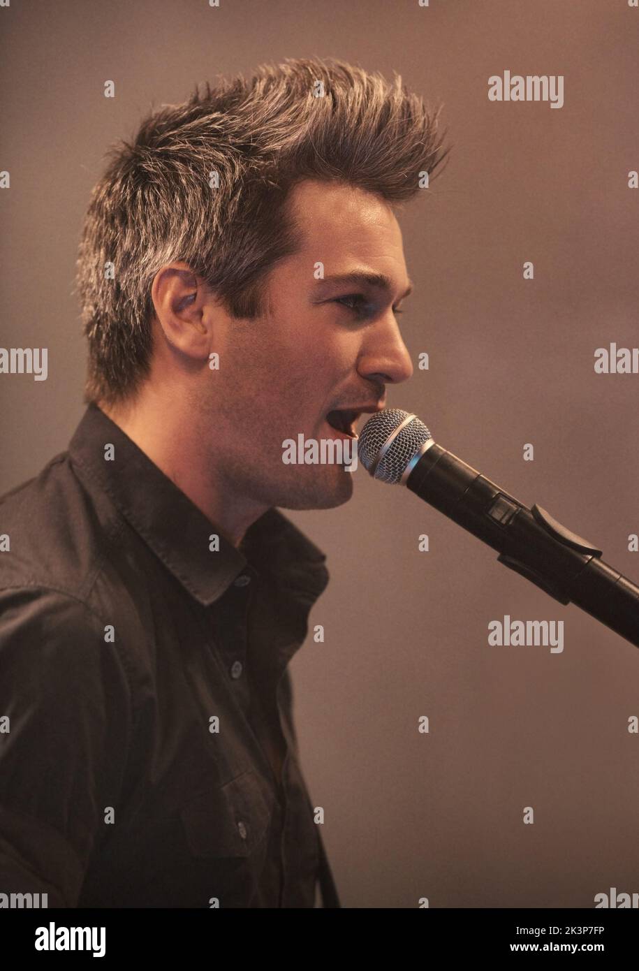 Make your voice heard. A young performer singing into a microphone ...