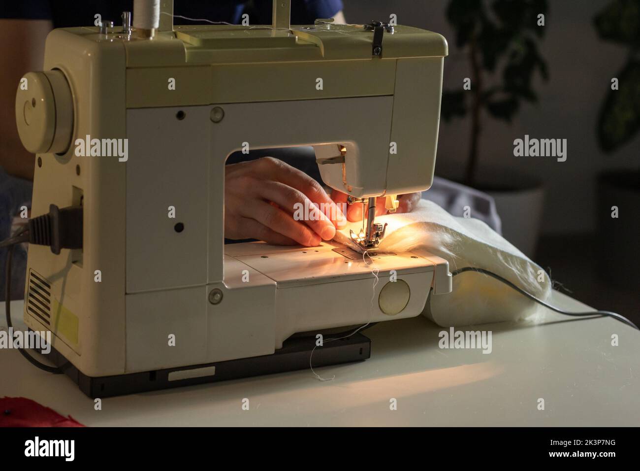 Hands of experienced worker in the handmade industry, sewing white ...