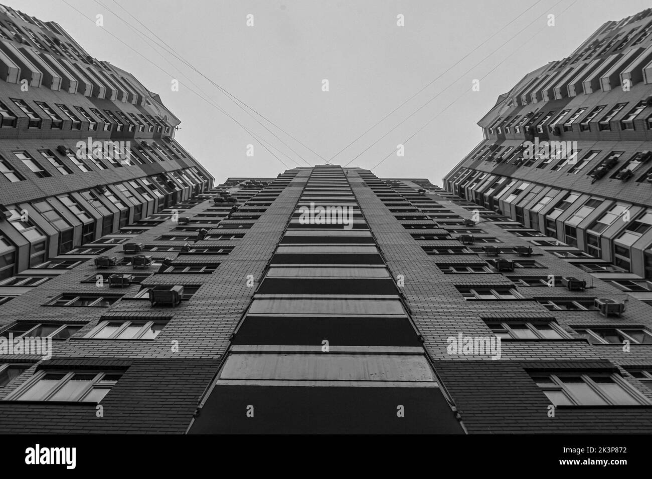 A low angle grayscale shot of large apartment building on clear sky ...