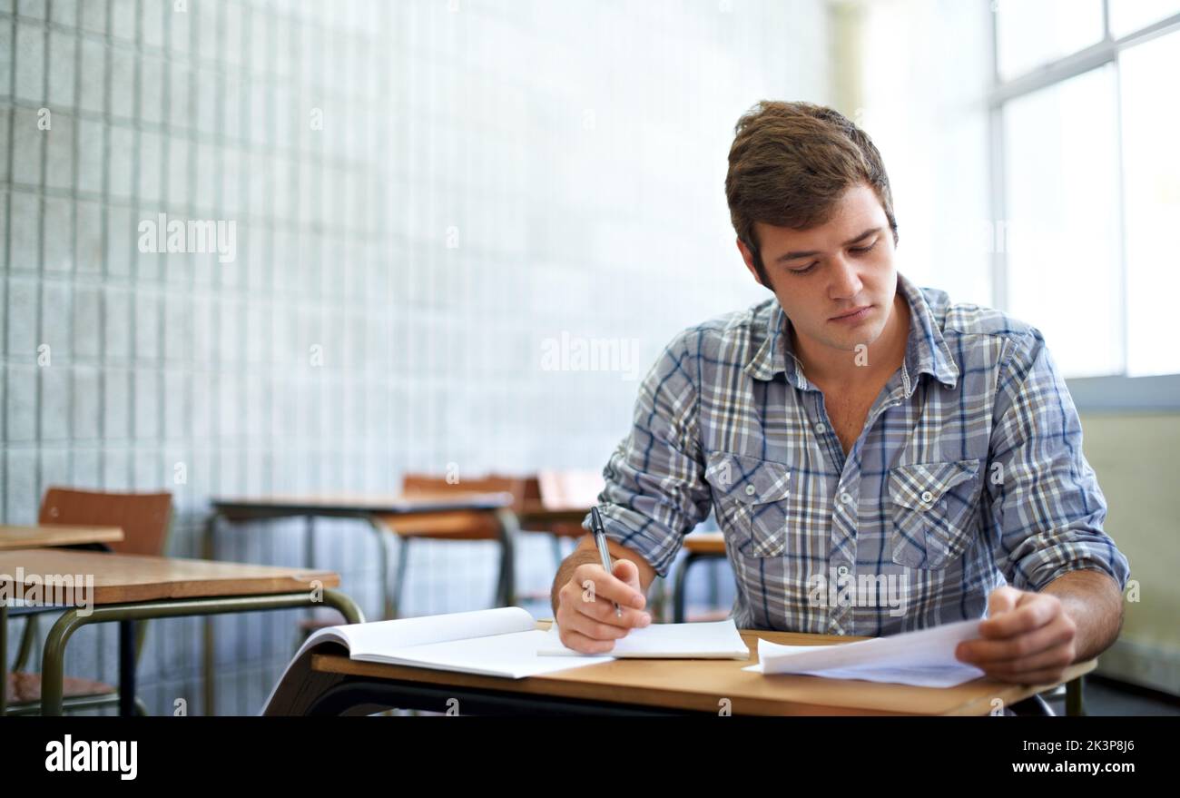 Working hard to achieve excellence. a young college student studying in ...