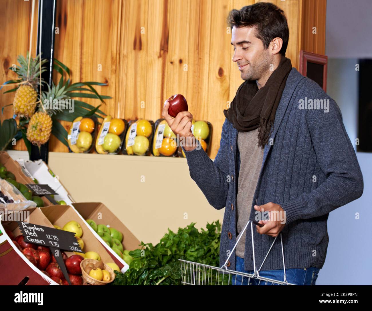 Only the freshest for him. a young man in a supermarket shopping for ...