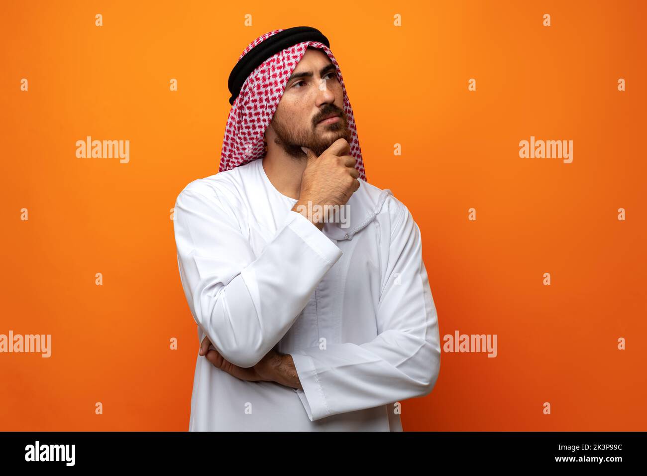 Young arab man wearing traditional clothes thinking about something ...