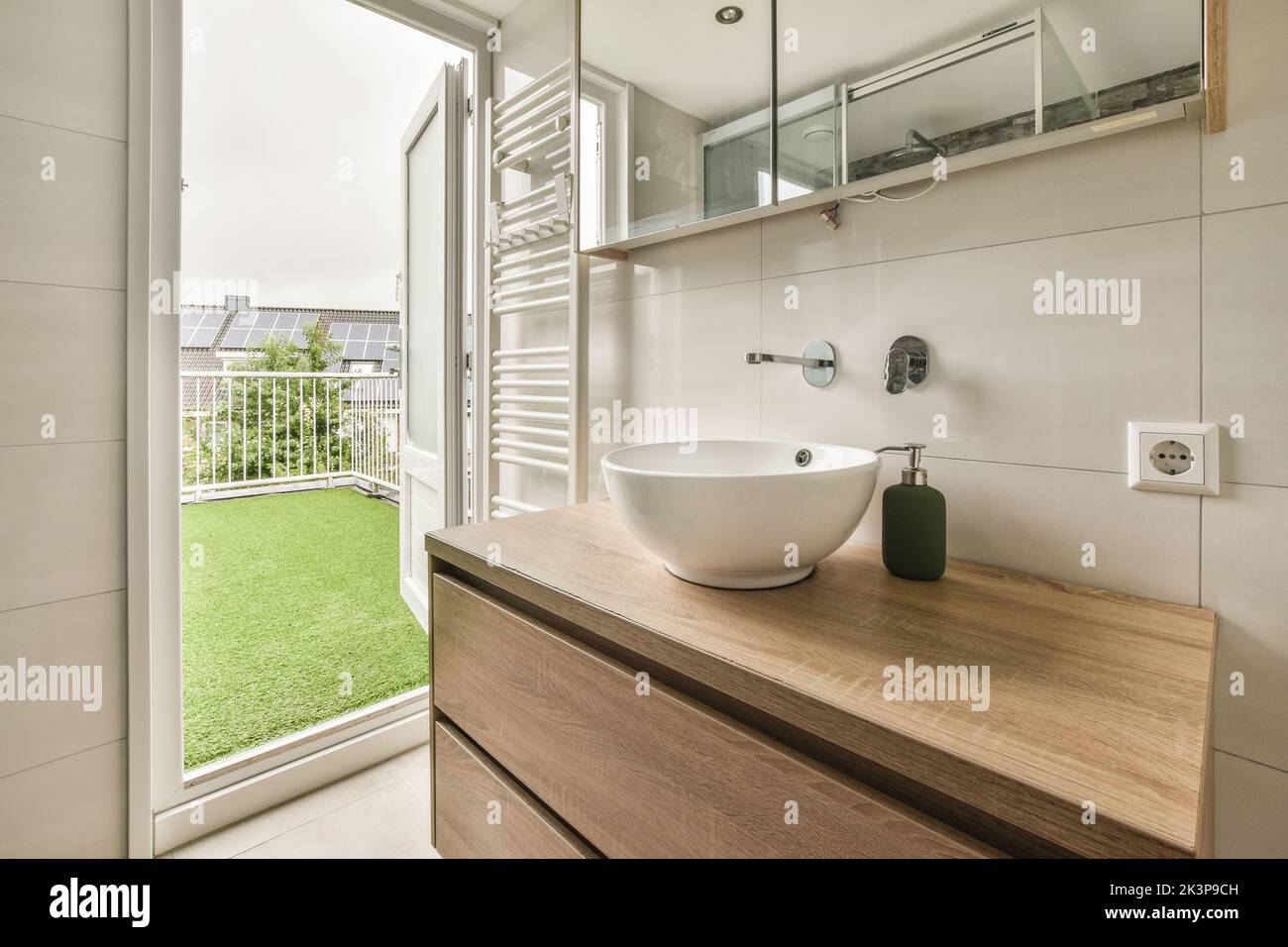 Shower faucets attached to tiled wall near glass partition and ...