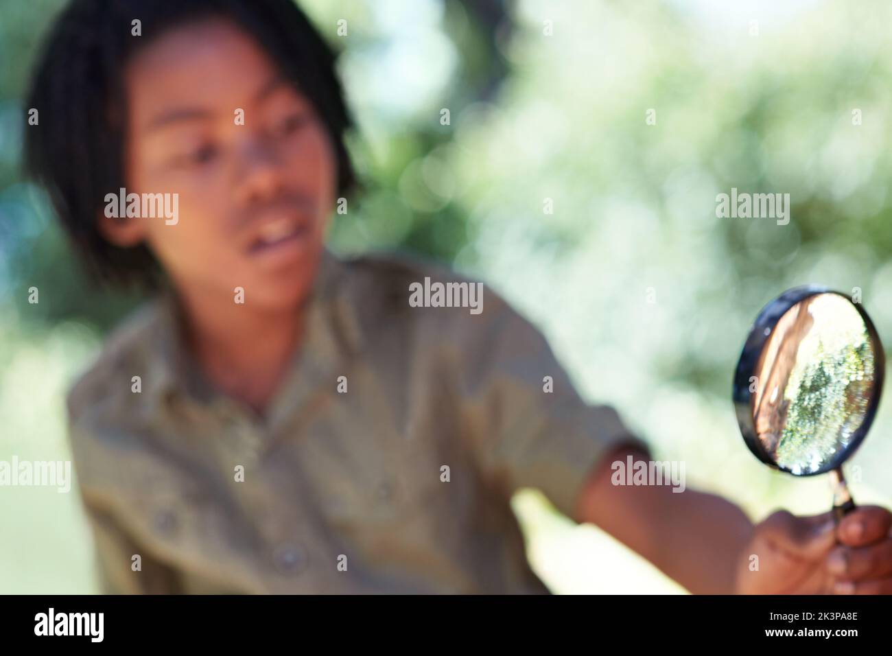 Finding little insects. A boy looking through a magnifying glass Stock ...