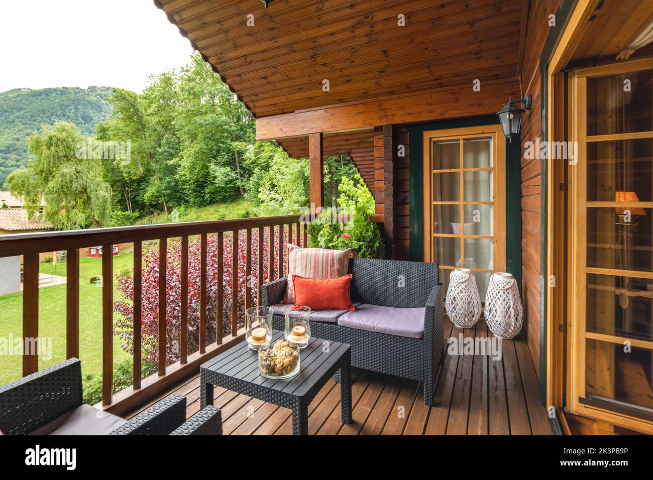 Cozy terrace with table and sofa at wooden cottage house surrounded by ...