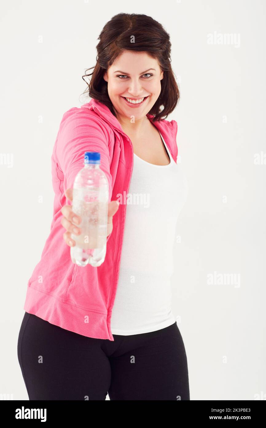 Heres some H2O. Studio shot of a young woman in sportswear offering a ...