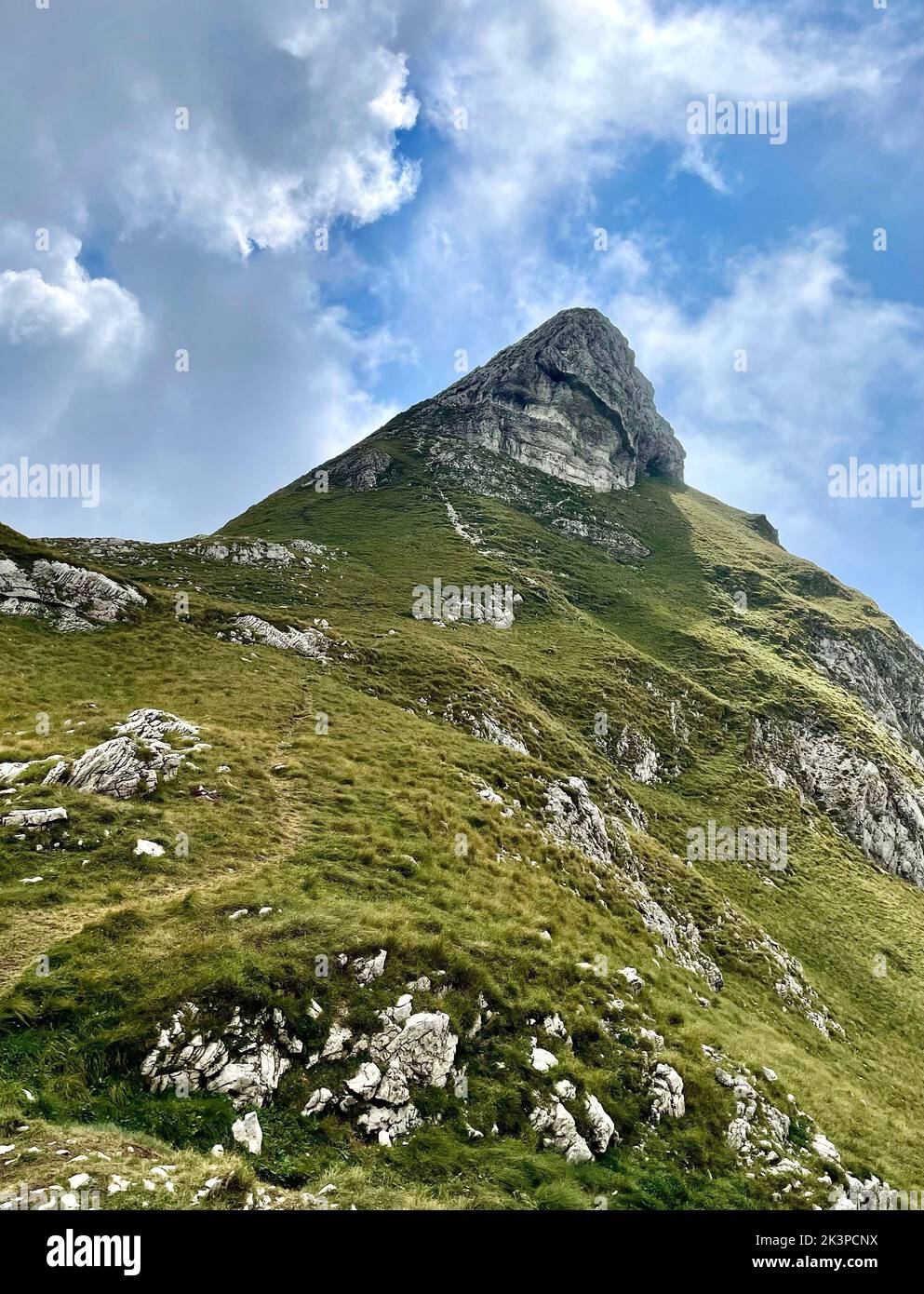 A vertical shot of a mountain peak in the cloudy sky Stock Photo - Alamy
