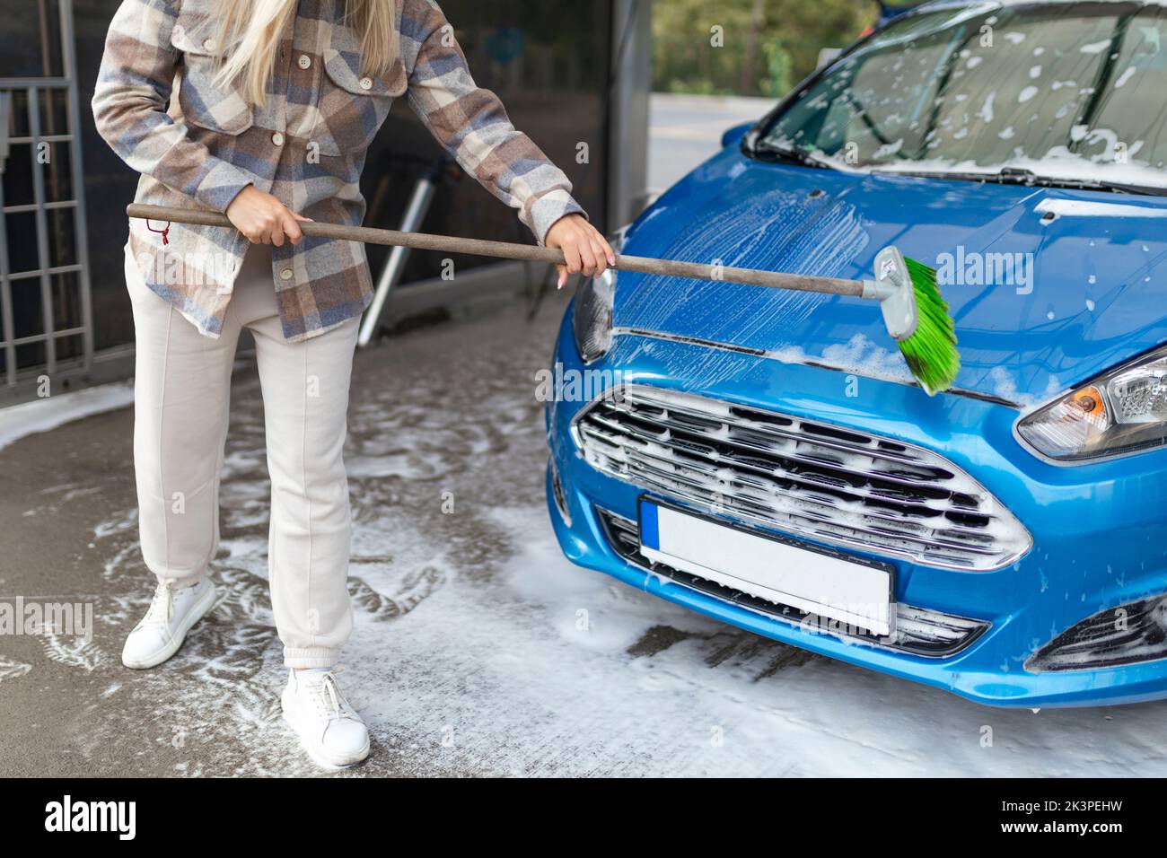 the women herself at the car wash washes the car with a brush Stock ...